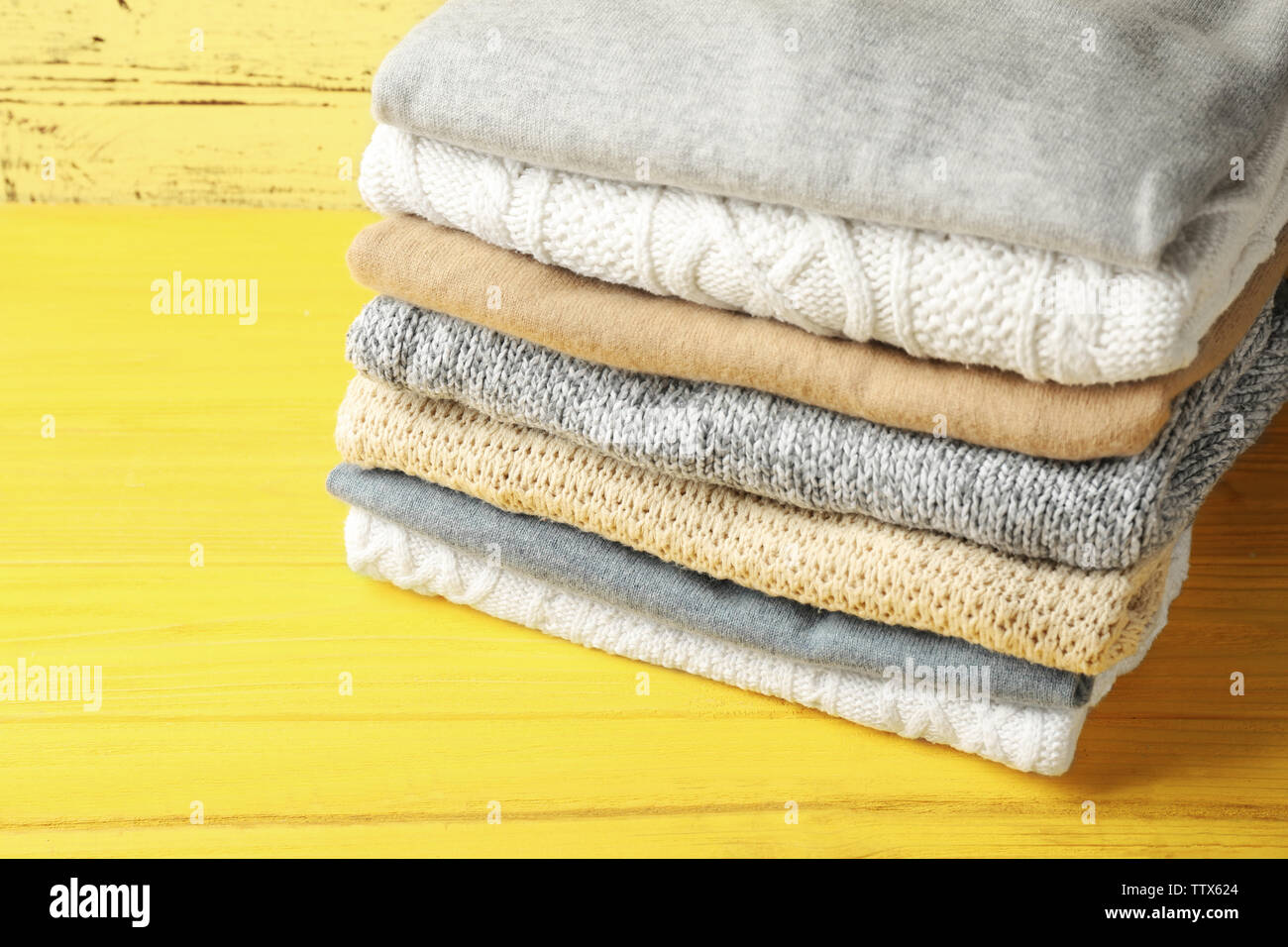 Stack of folded clothes on wooden background Stock Photo - Alamy