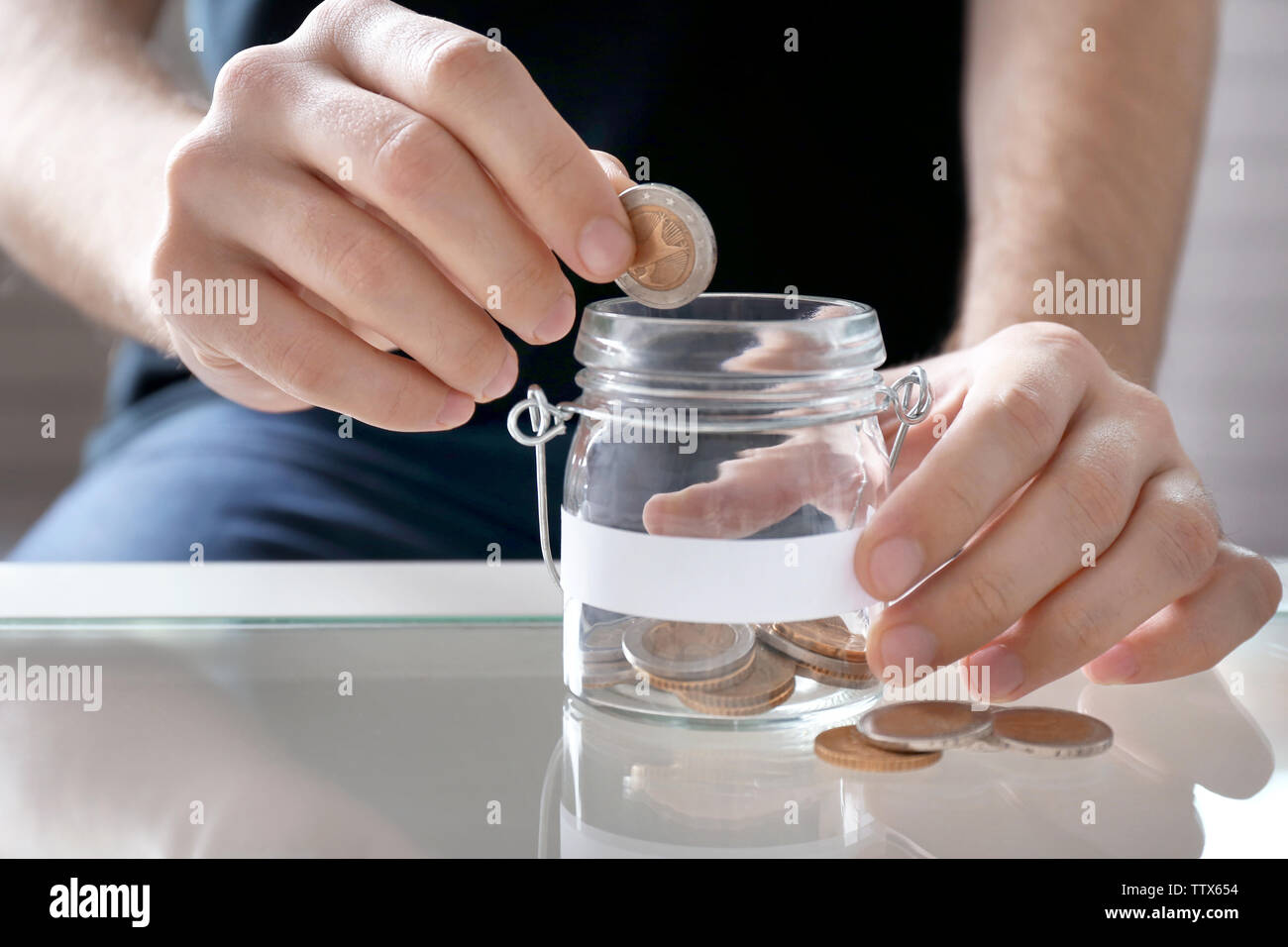 Man putting money coins glass hi-res stock photography and images - Alamy