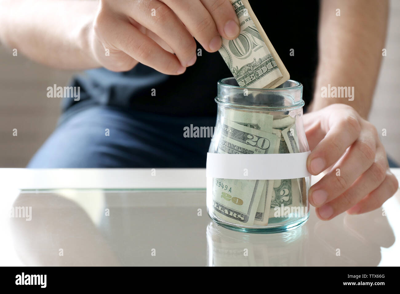 Hand holding money putting glass hi-res stock photography and images ...