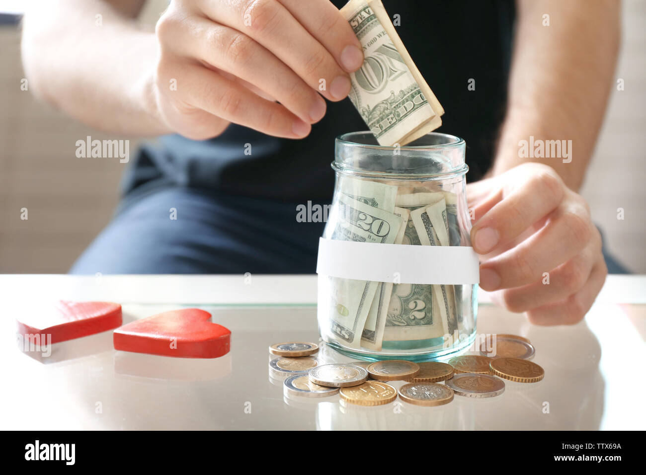 Man putting money coins glass hi-res stock photography and images - Alamy