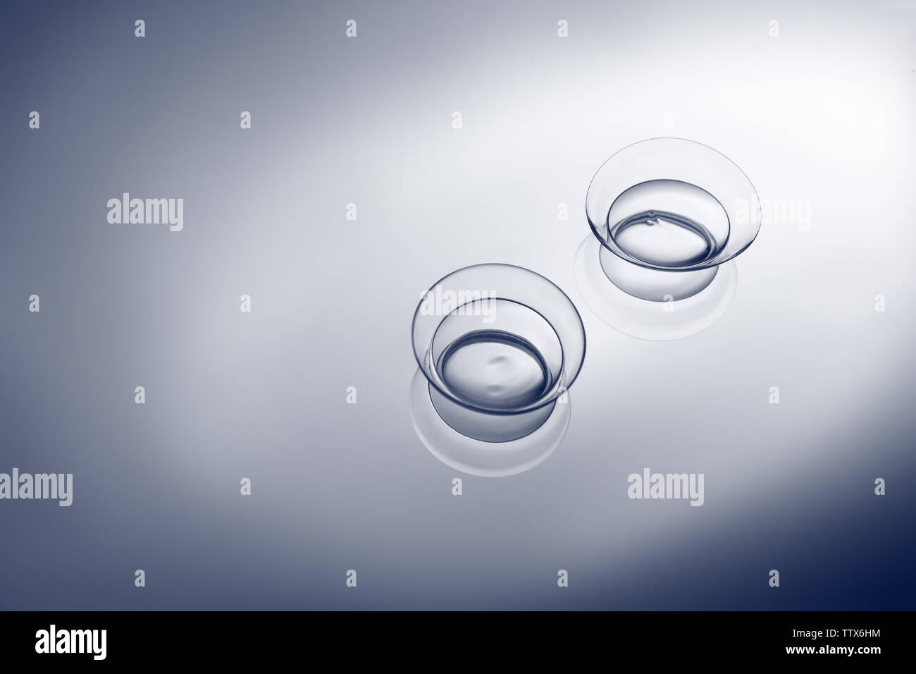 Pair of contact lenses on smooth light background, close up view ...