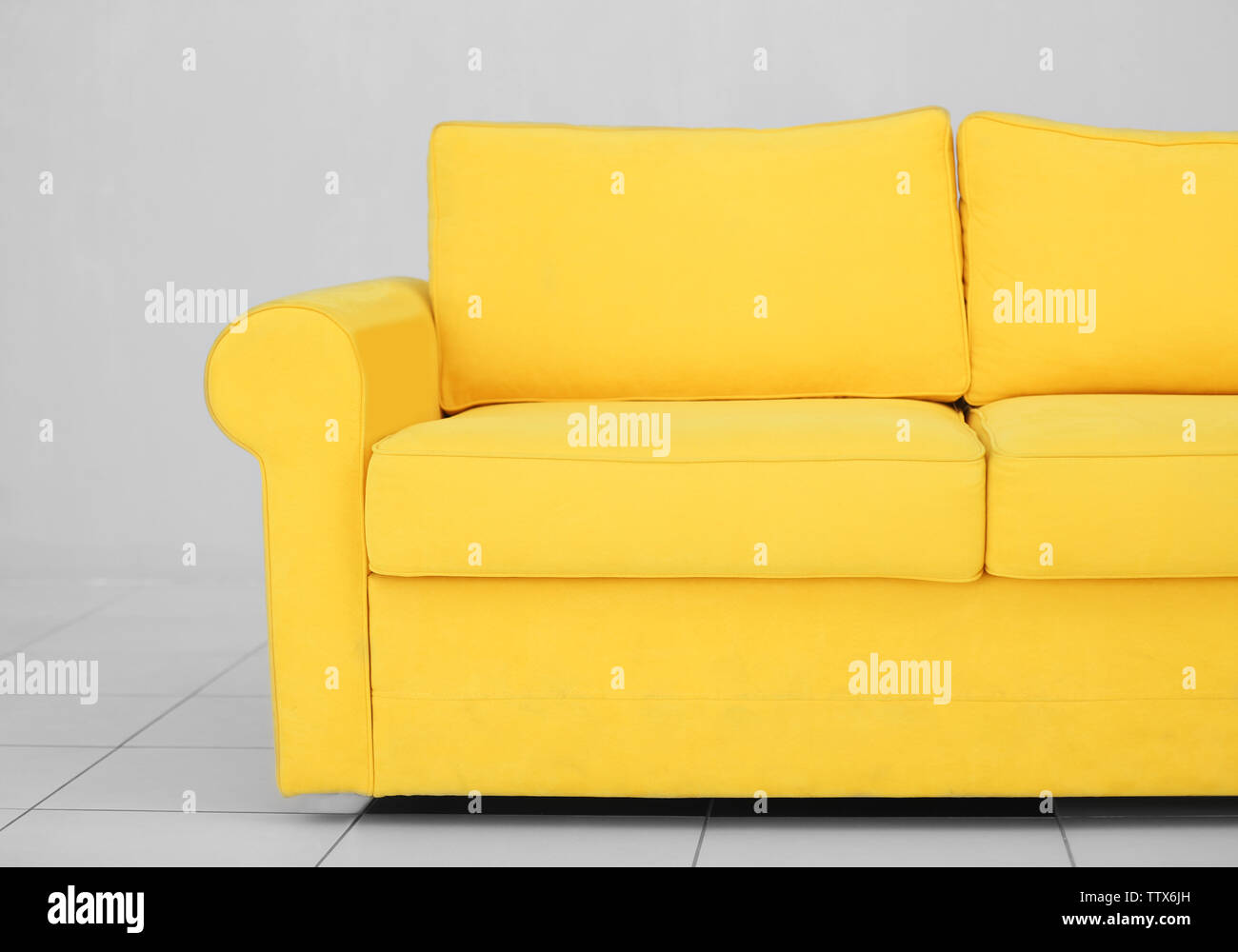 New cozy sofa on light wall background Stock Photo - Alamy