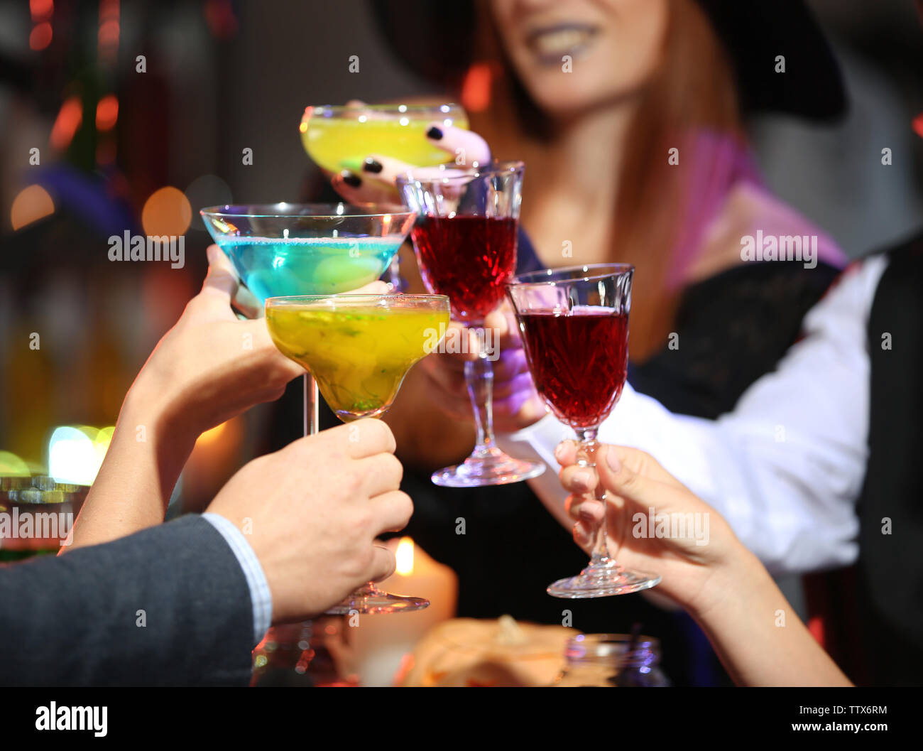 People drinking colorful cocktails at party, closeup. Halloween concept ...