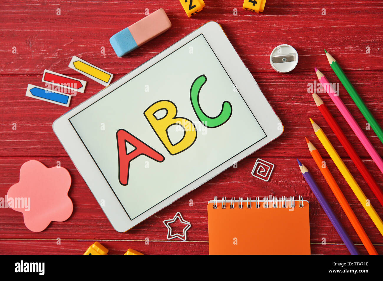 Tablet with ABC and colourful stationery, top view Stock Photo - Alamy