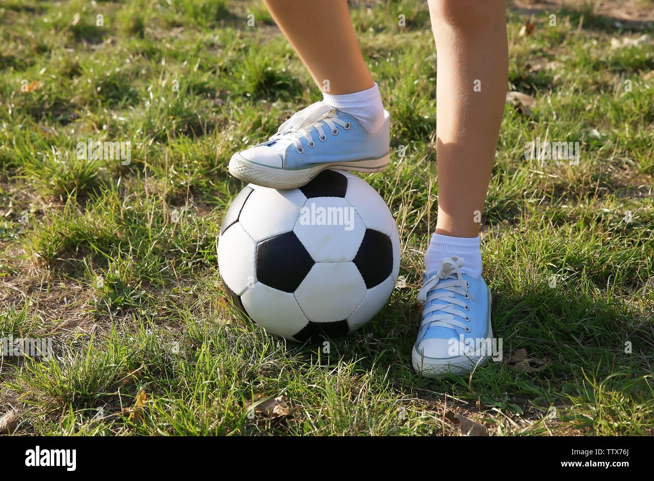 Boy legs with football ball on field Stock Photo - Alamy