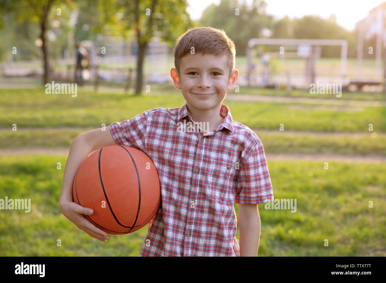 Cute boy with basketball ball on street Stock Photo - Alamy