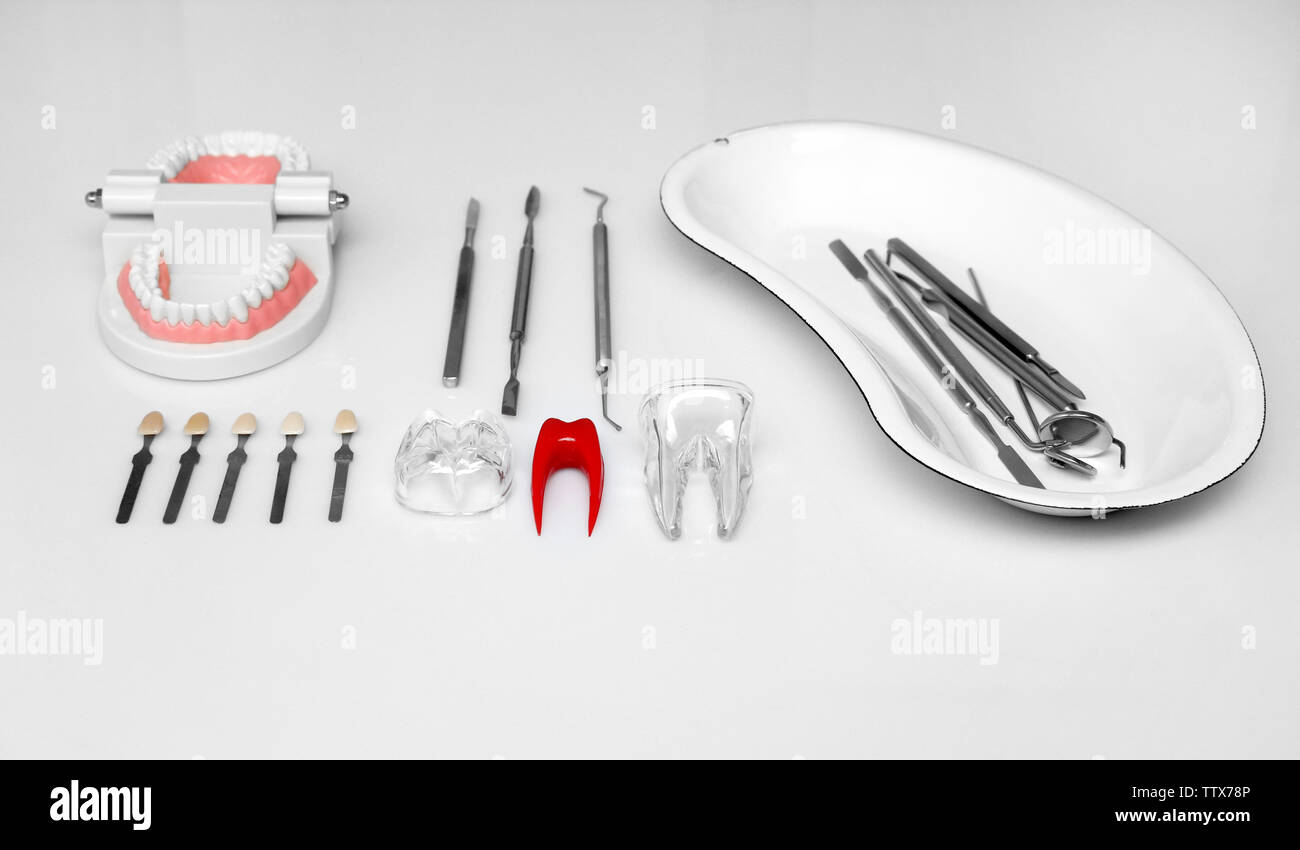 Artificial jaw and teeth with dental tools on white background Stock ...