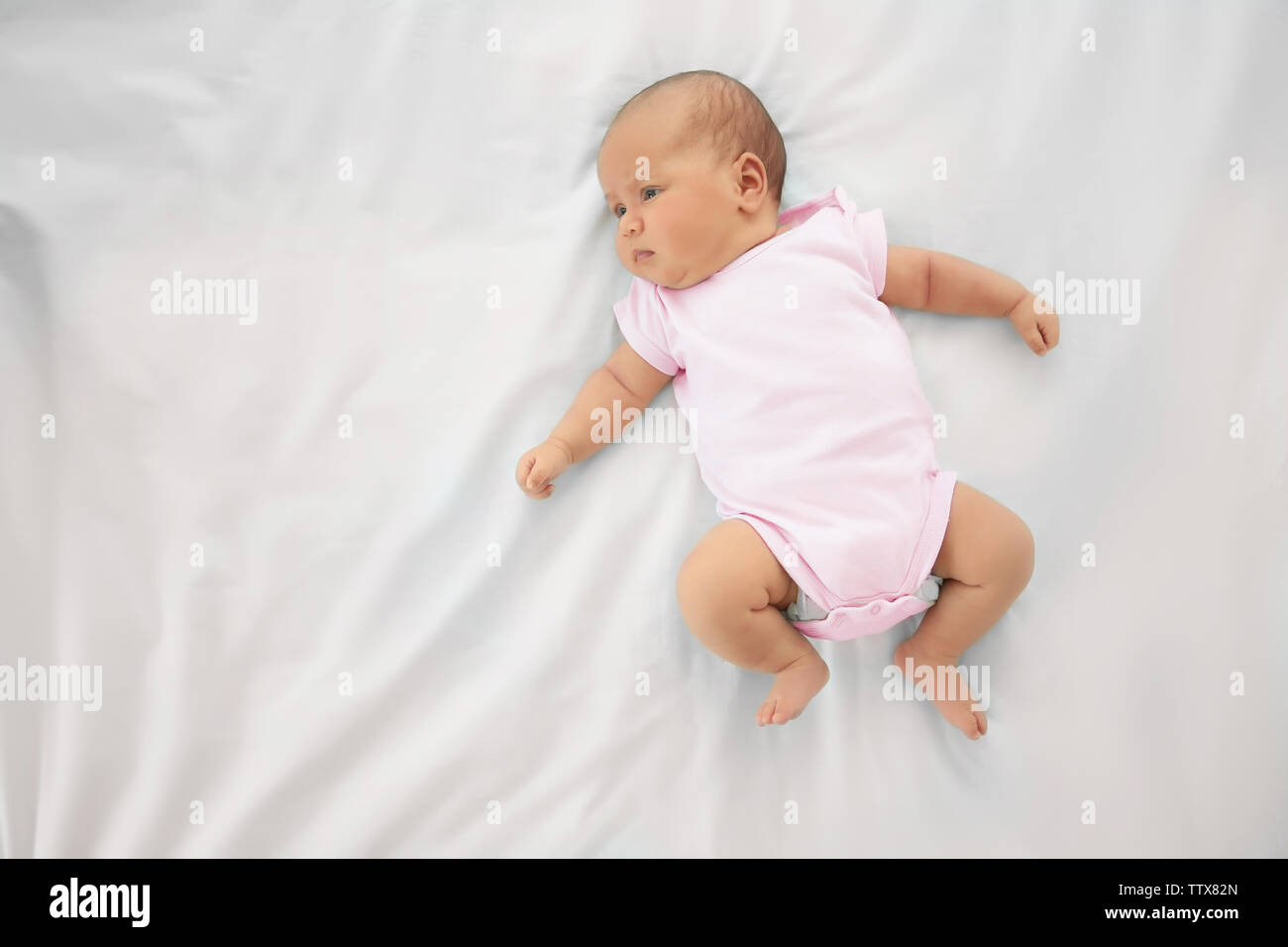 Cute baby on bed, top view Stock Photo - Alamy