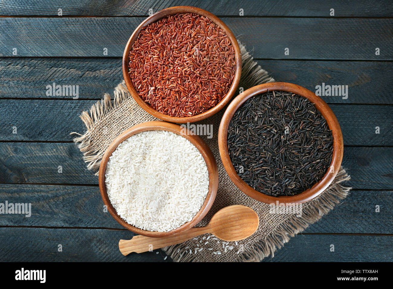 Different types of rice in bowls on wooden table, top view Stock Photo ...