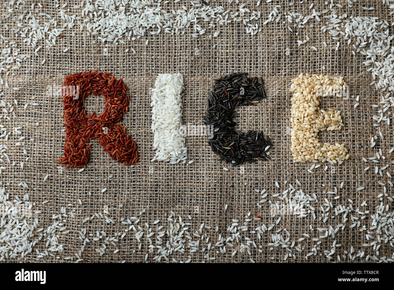 Word RICE made with different types of grains on sackcloth background ...
