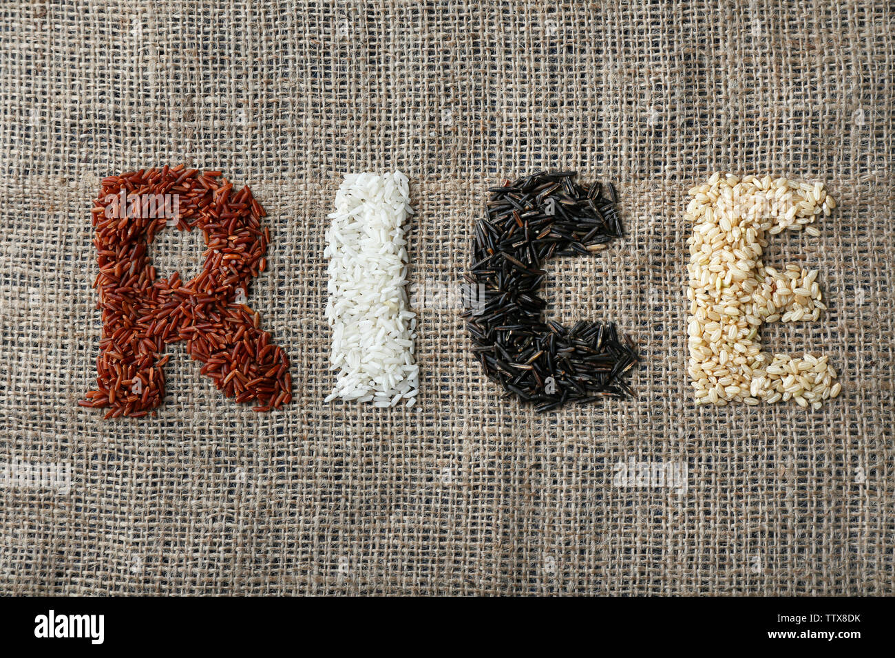 Word RICE made with different types of grains on sackcloth background ...