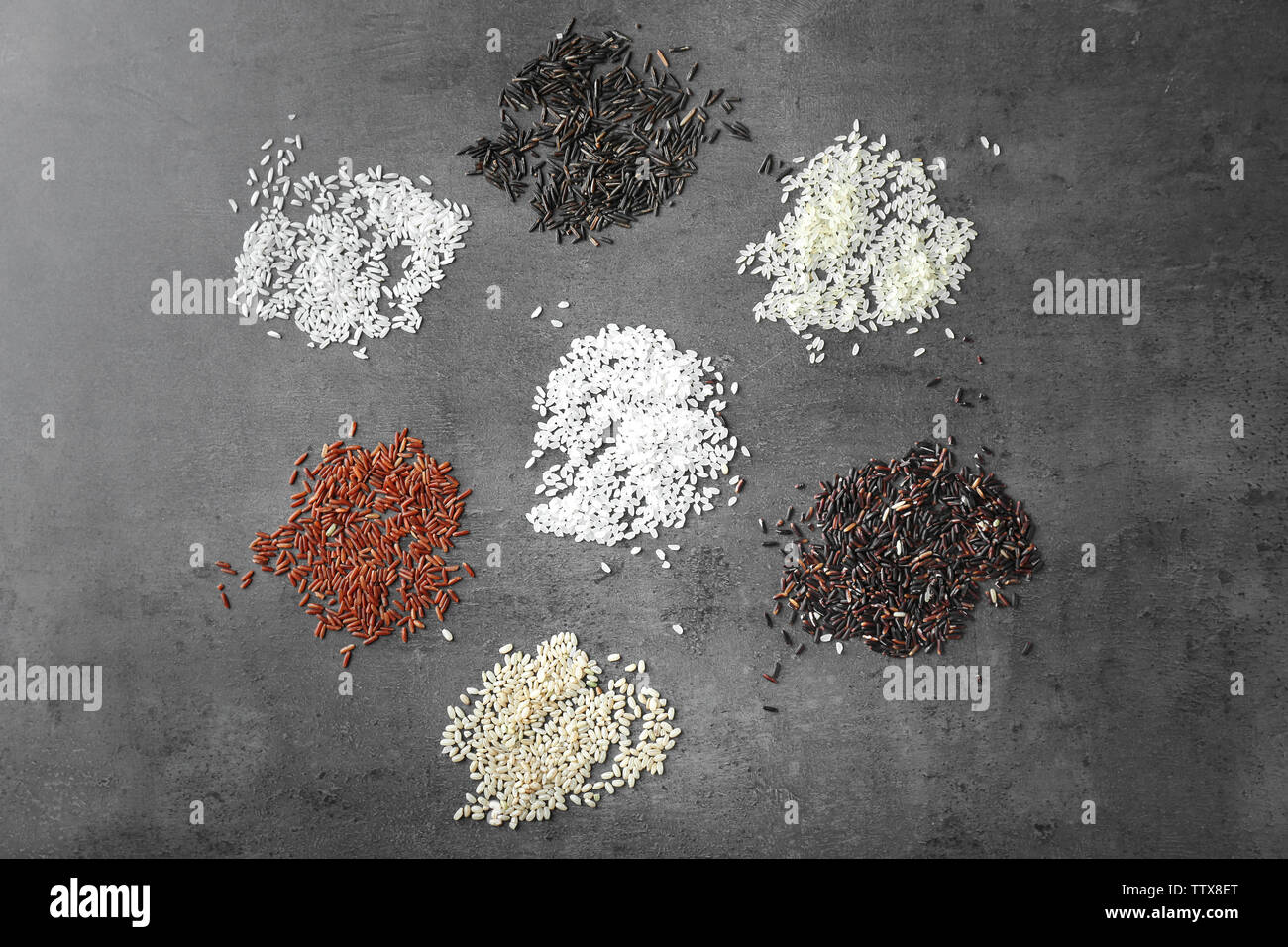 Different types of rice on grey textured background Stock Photo - Alamy