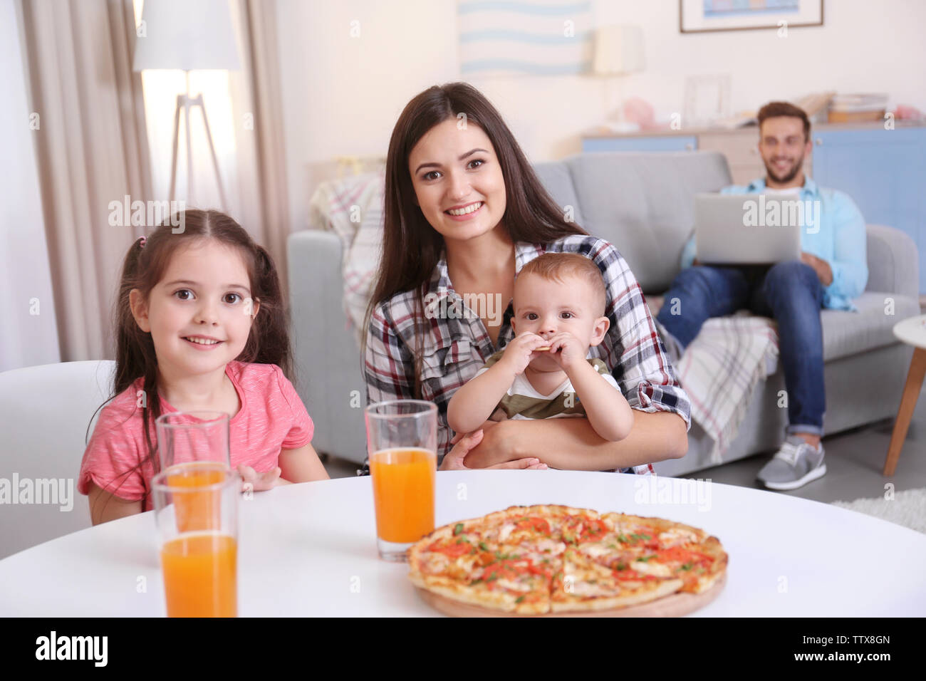 Happy family eating food on kitchen Stock Photo - Alamy