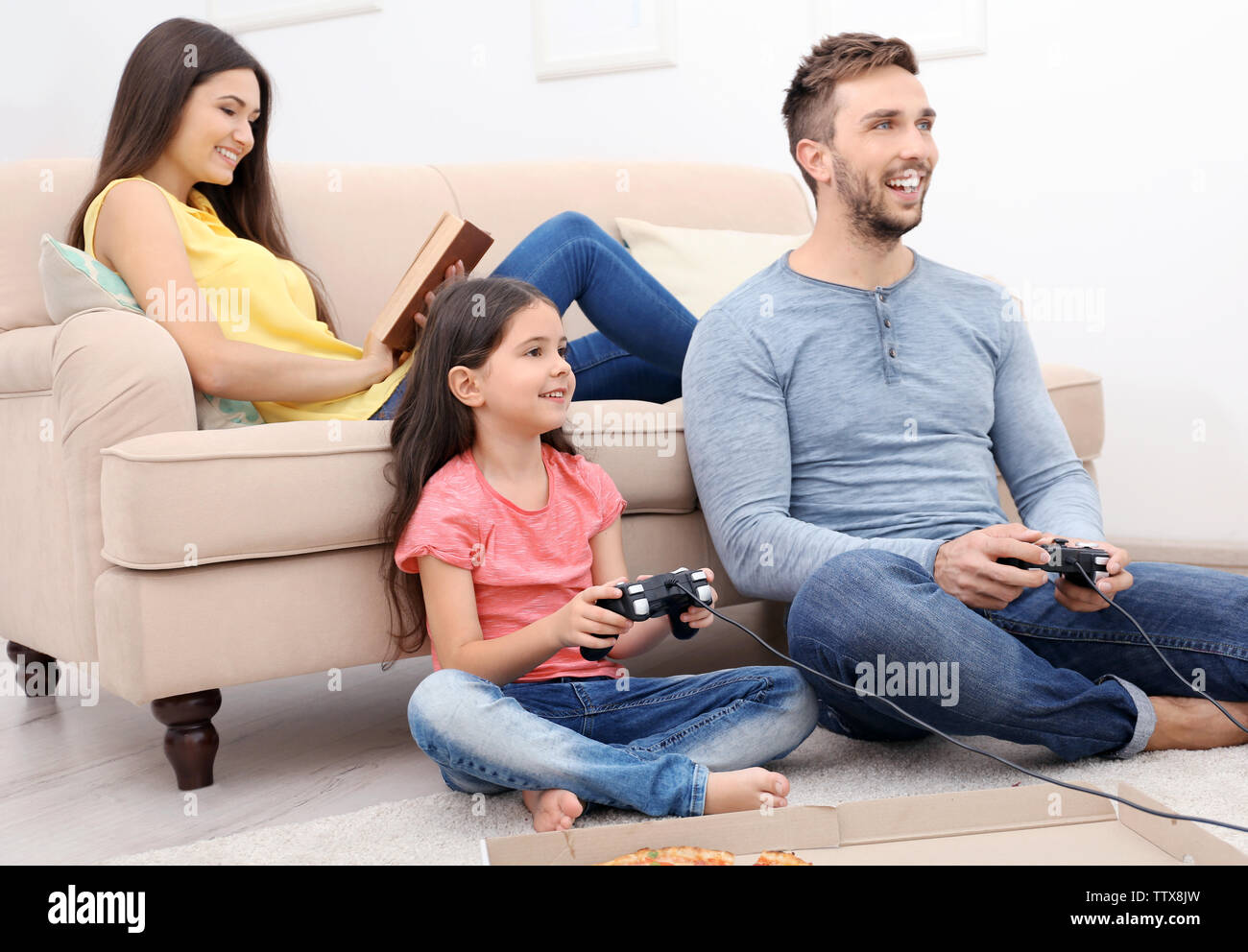 Happy family playing video games at home Stock Photo - Alamy