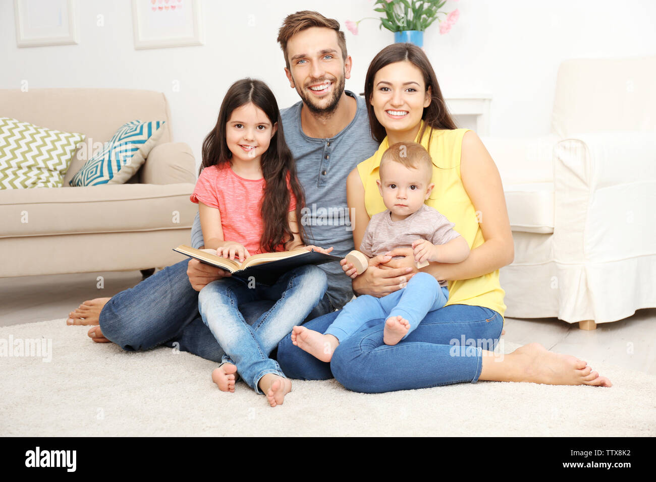 Happy family reading book at home Stock Photo - Alamy