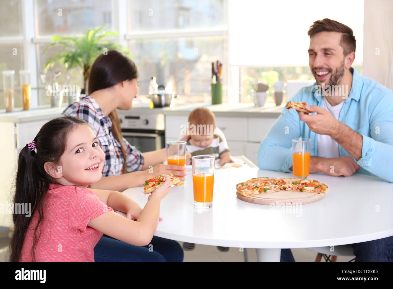 Happy family eating food on kitchen Stock Photo - Alamy