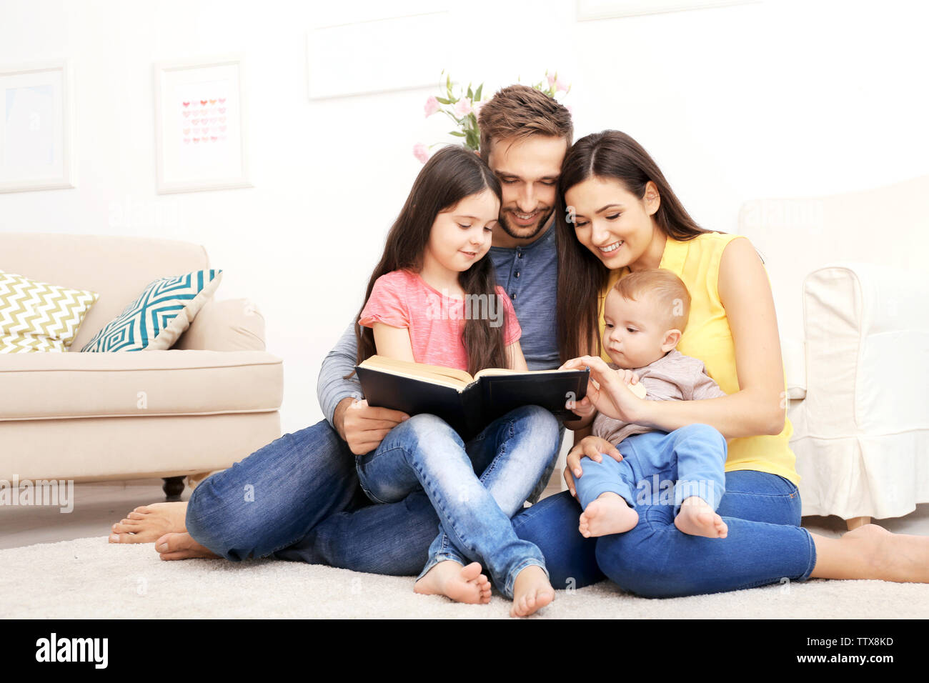 Happy family reading book at home Stock Photo - Alamy