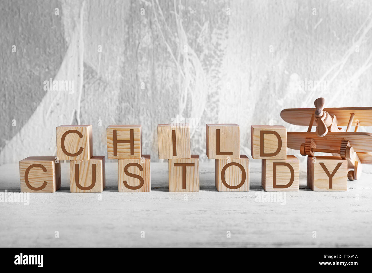 Cubes with text CHILD CUSTODY and toy plane on wall background Stock ...