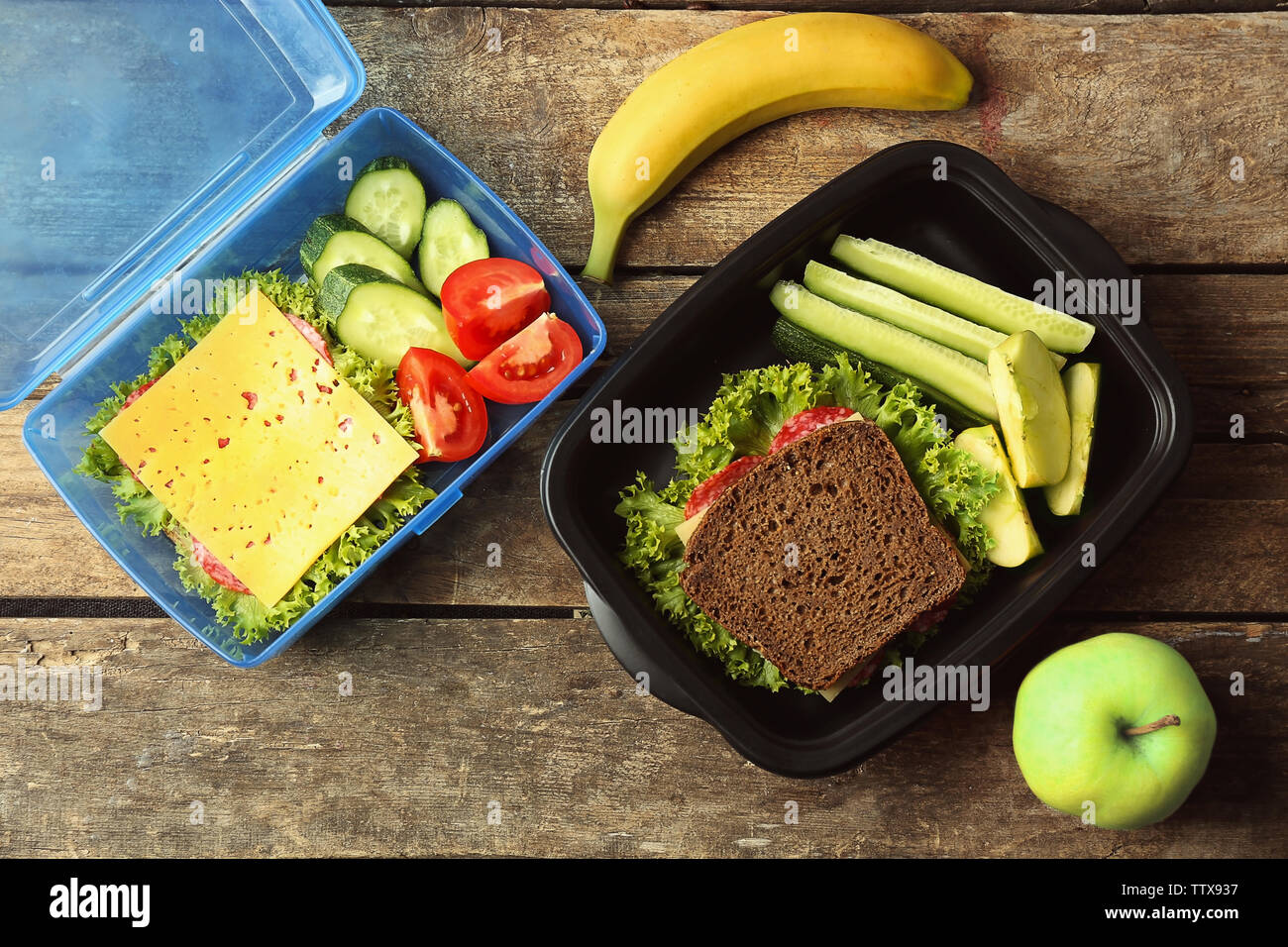 Lunch boxes with food on wooden background Stock Photo - Alamy