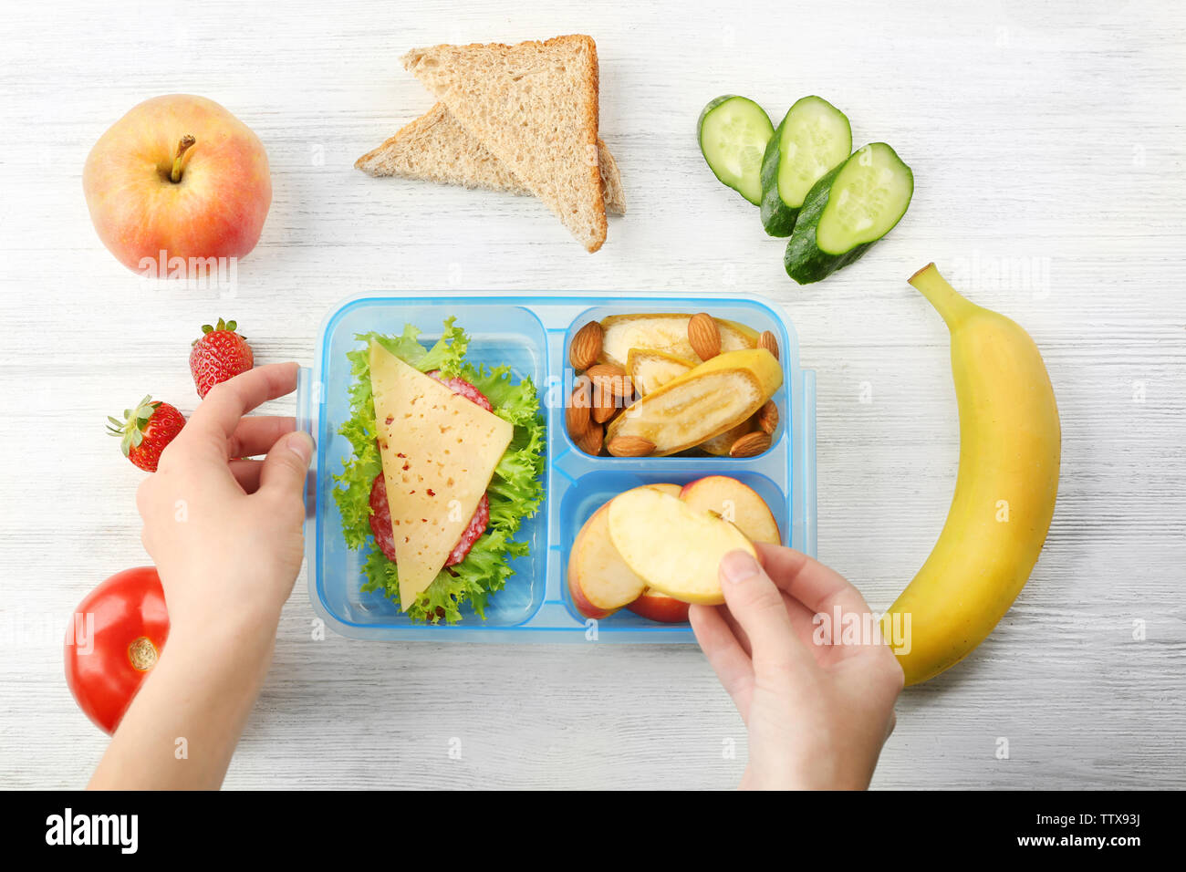Mother putting food in lunch box, top view Stock Photo - Alamy
