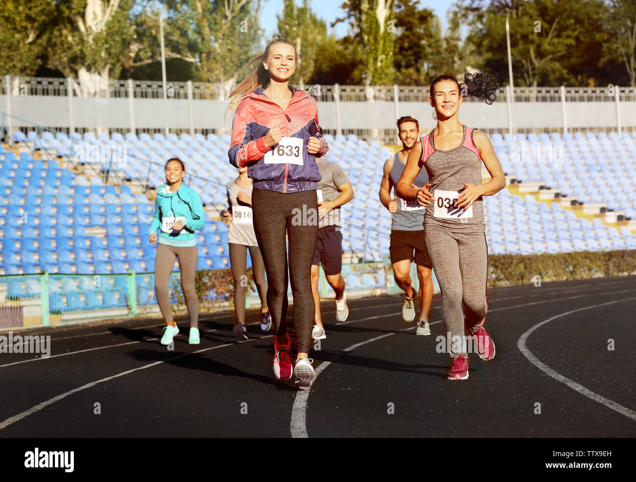 Sportsmen running at stadium Stock Photo - Alamy