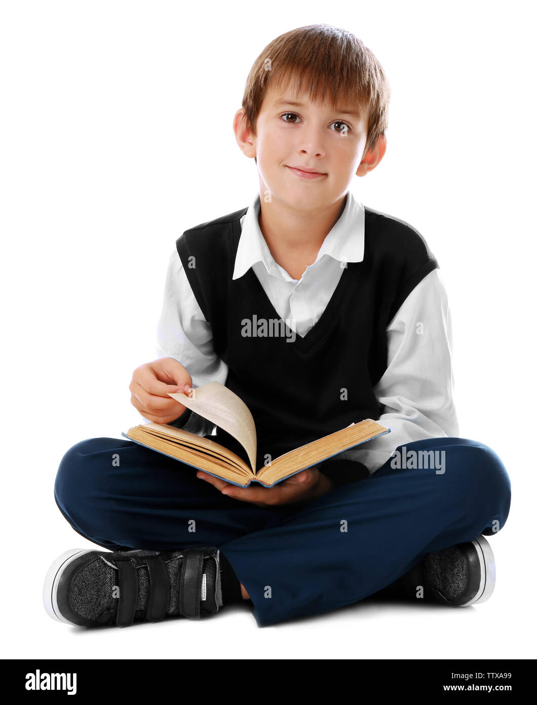 Cute schoolboy sitting with book on white background Stock Photo - Alamy