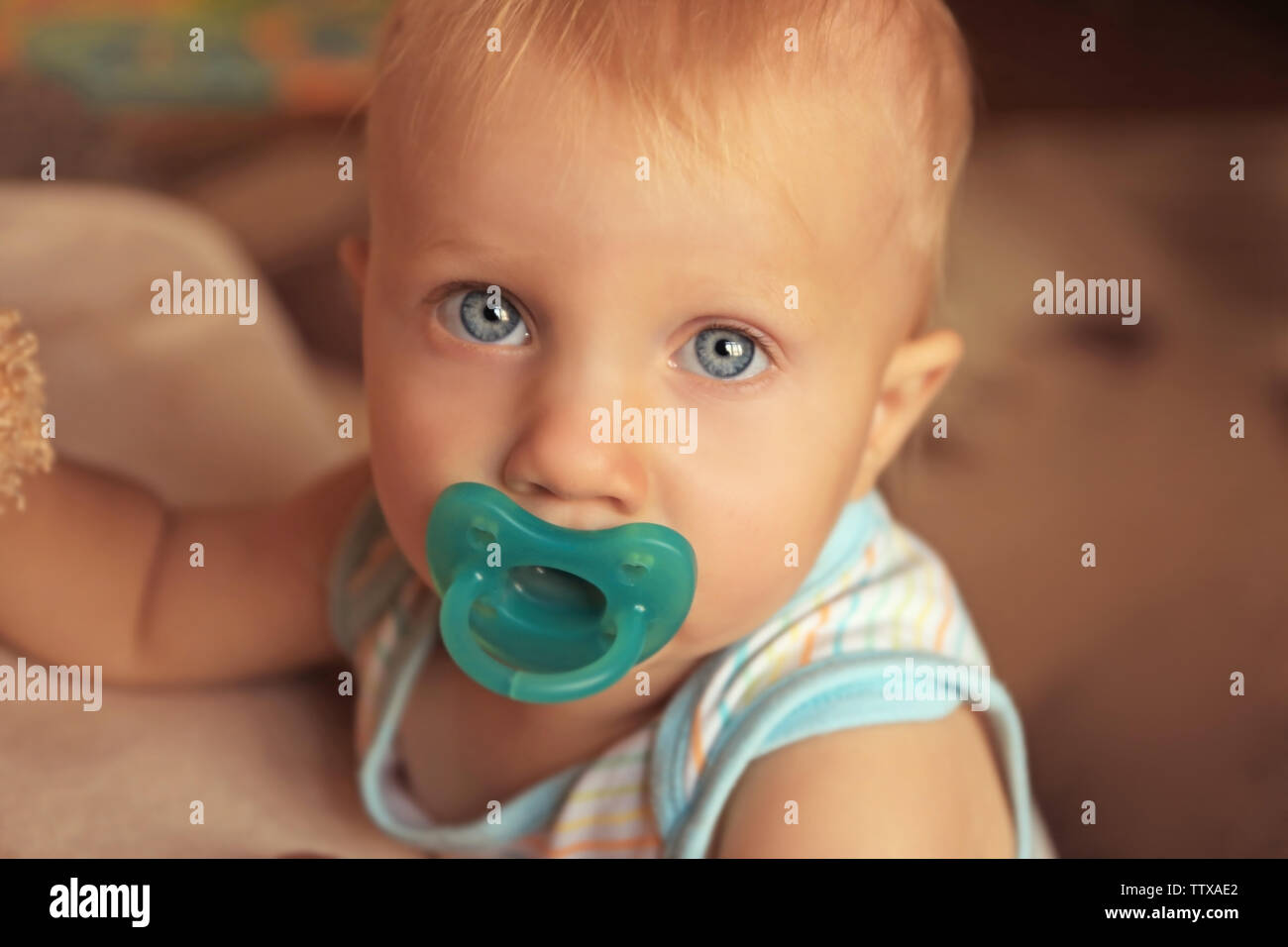 Cute little boy with dummy on blurred background, close up view Stock ...