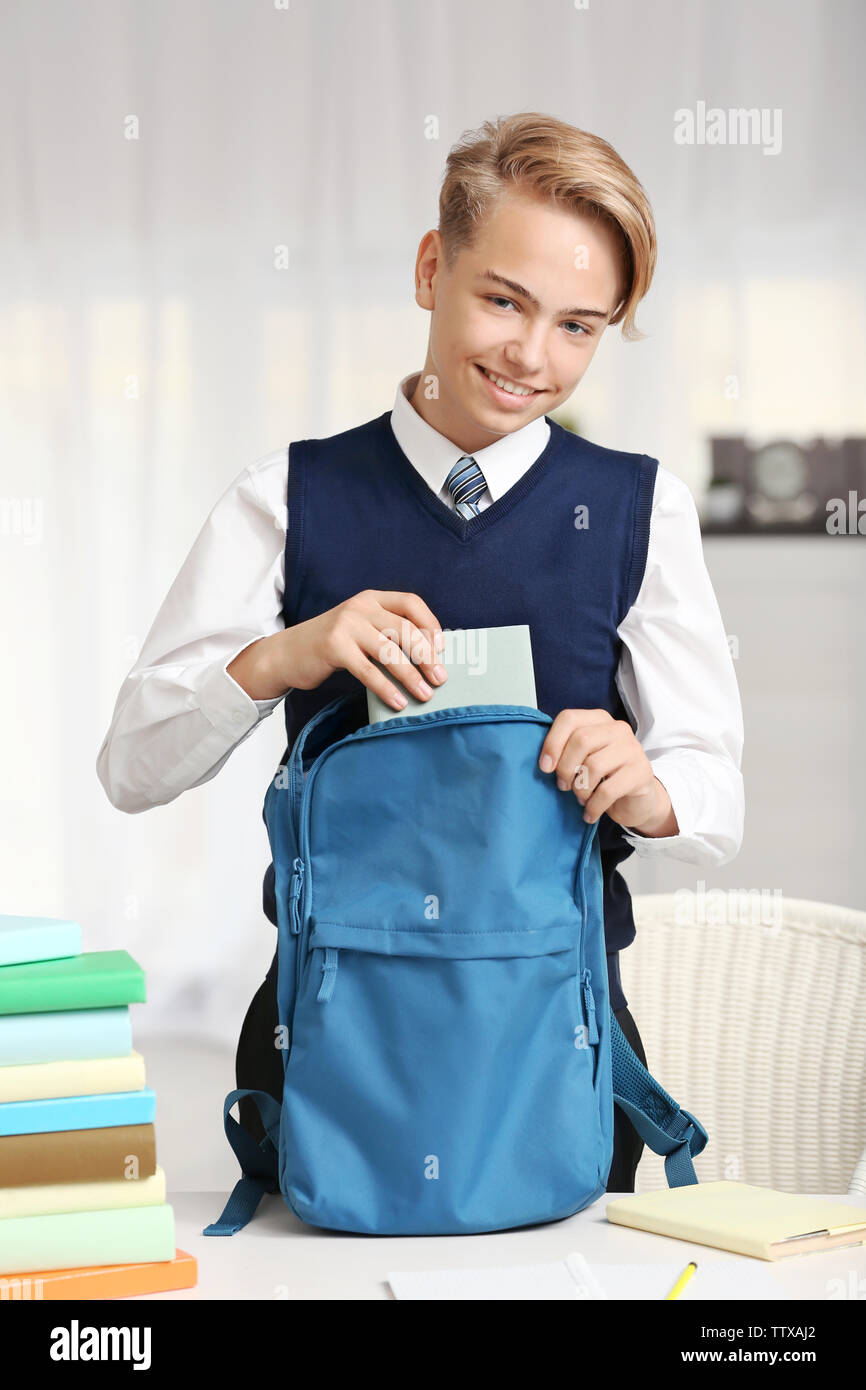 Schoolboy putting book into bag Stock Photo - Alamy