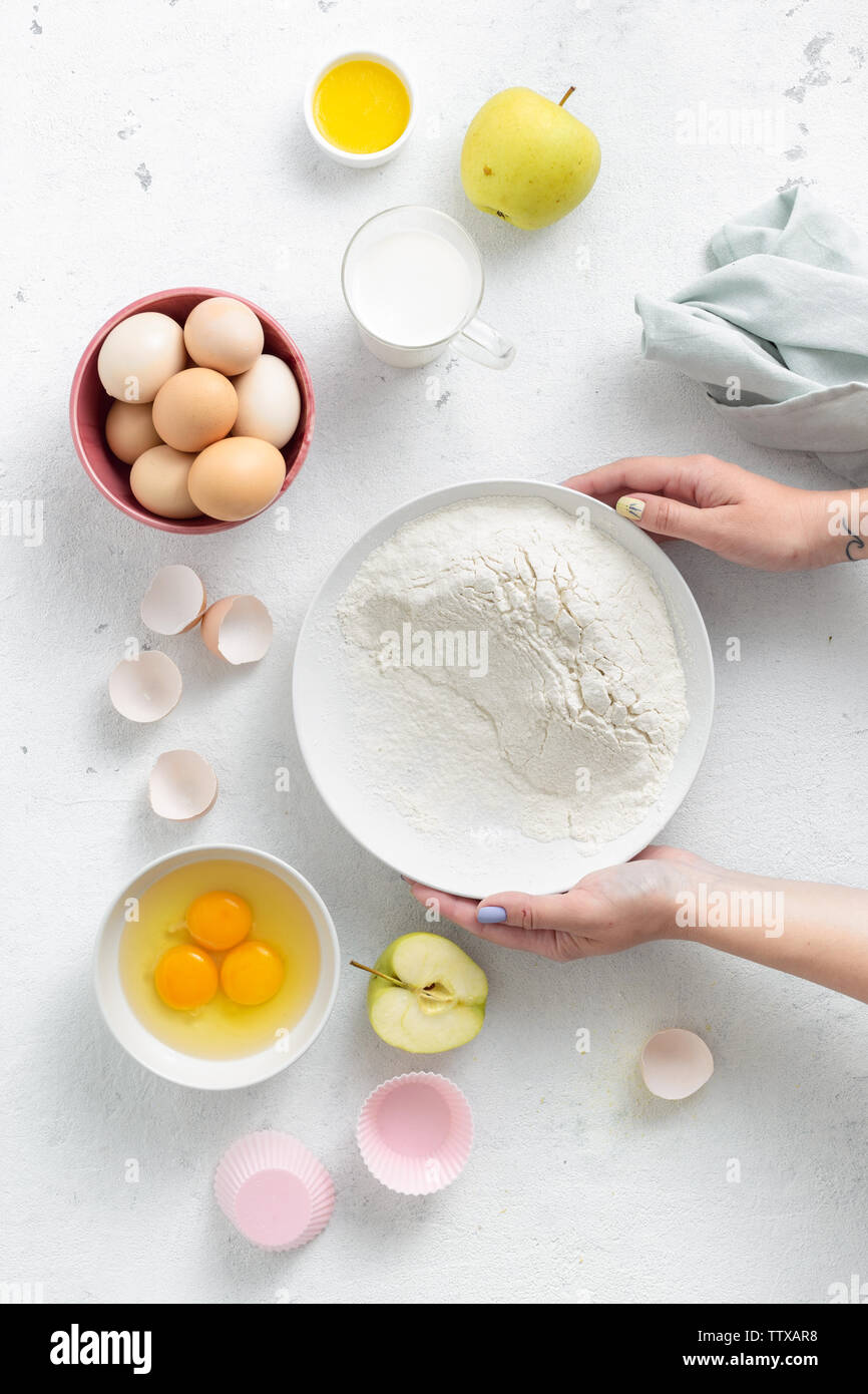 Person cooking dessert. Women hands preparing apple pie on a white ...