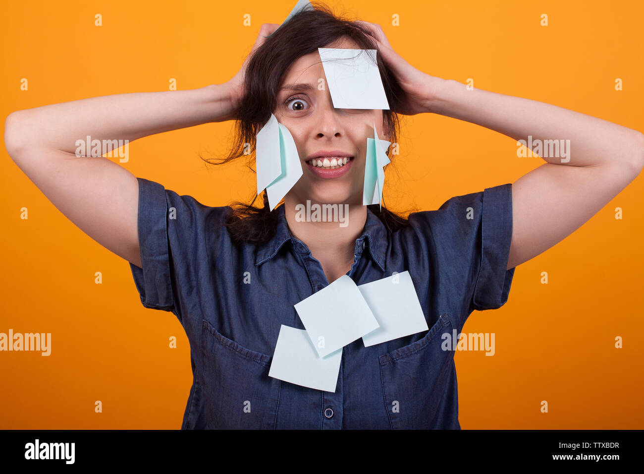 Portrait of young beautiful woman stressed with sticky notes on clothes ...