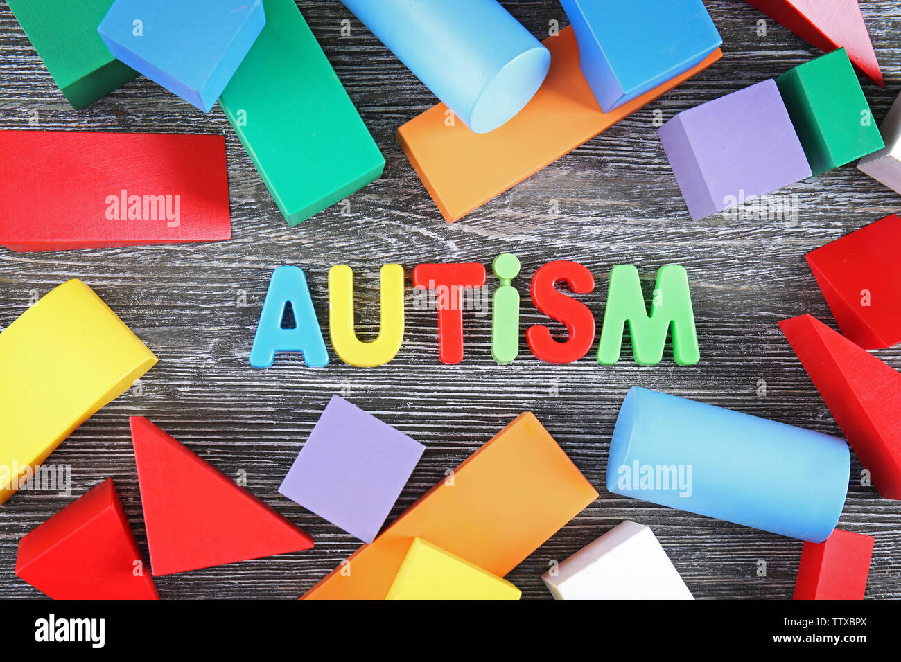 Word Autism with colorful figures on wooden background Stock Photo - Alamy