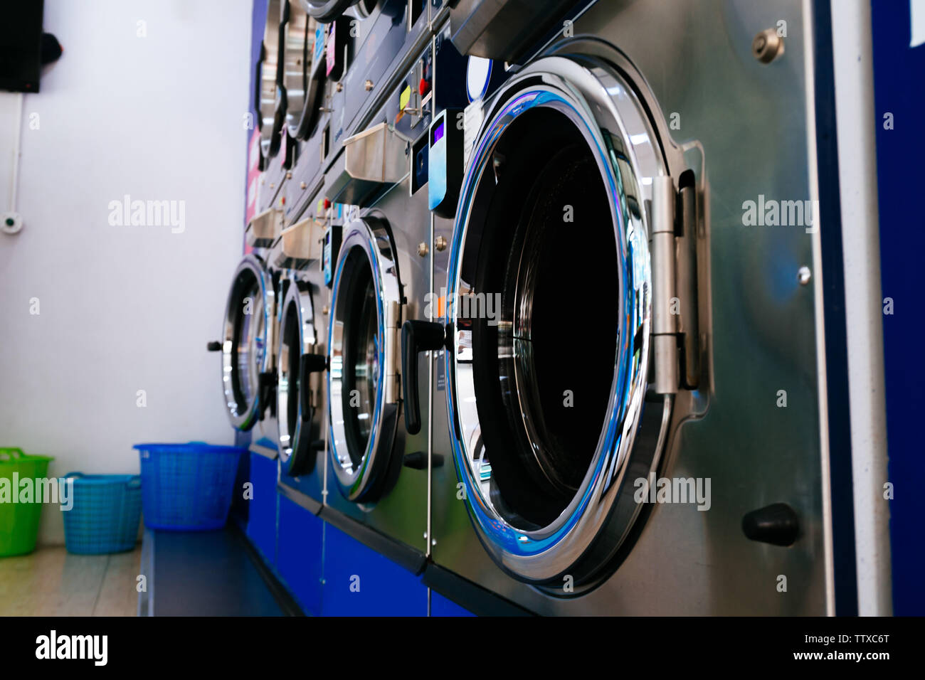Bunch of professional industrial washing and drying machines in laundry ...