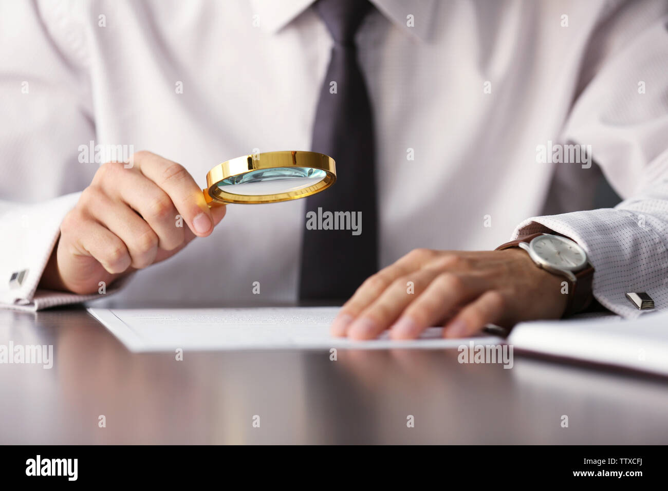 Businessman reading documents with magnifier Stock Photo - Alamy