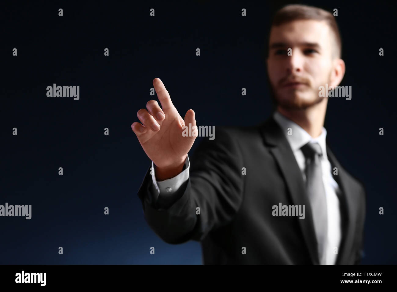 Businessman hand pointing, dark background Stock Photo - Alamy