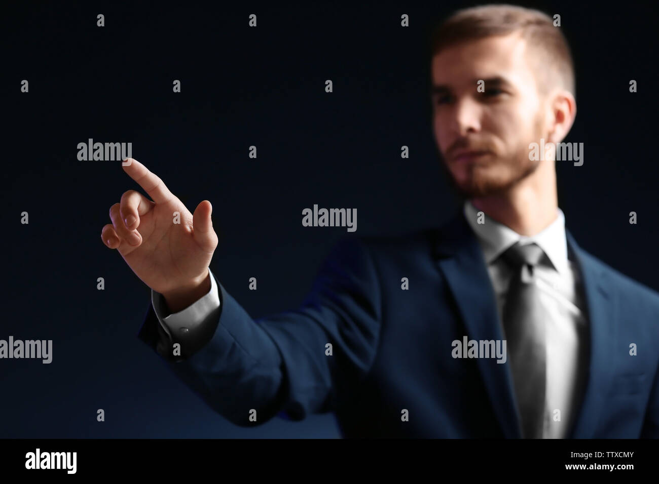 Businessman hand pointing, dark background Stock Photo - Alamy