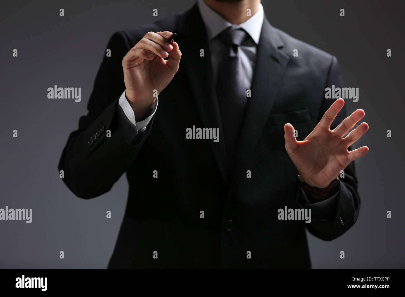 Businessman hand pointing, grey background Stock Photo - Alamy