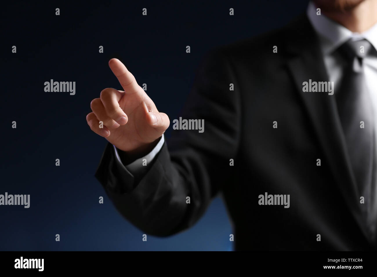 Businessman hand pointing, dark background Stock Photo - Alamy