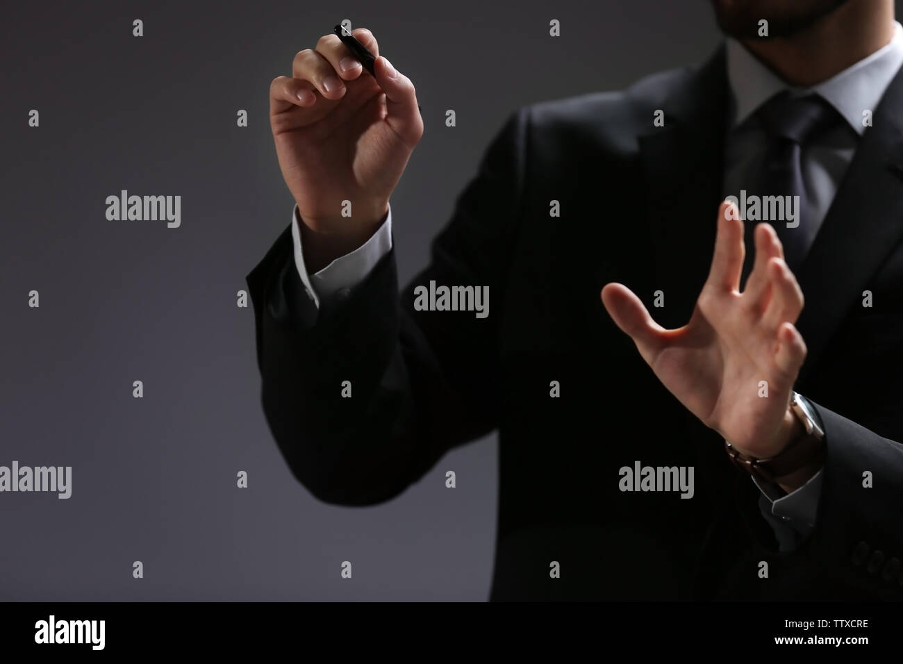Businessman hand pointing, grey background Stock Photo - Alamy