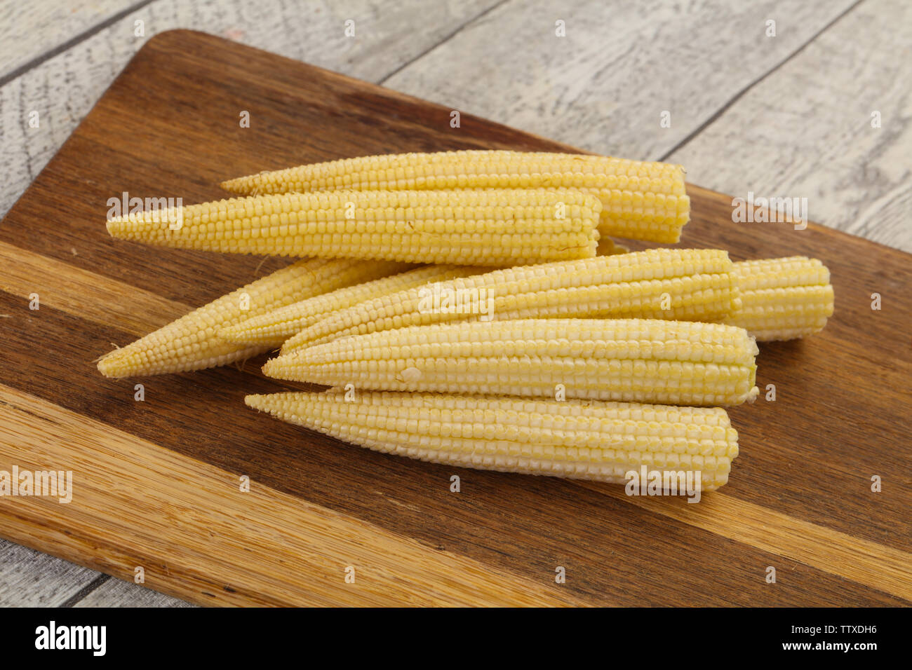 Raw baby corn over the wooden board Stock Photo - Alamy