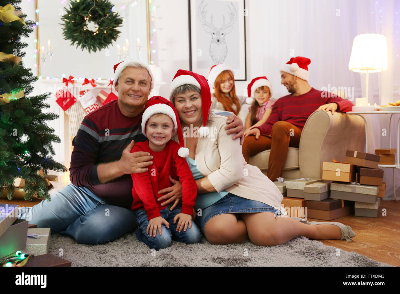 Family in living room decorated for Christmas Stock Photo - Alamy