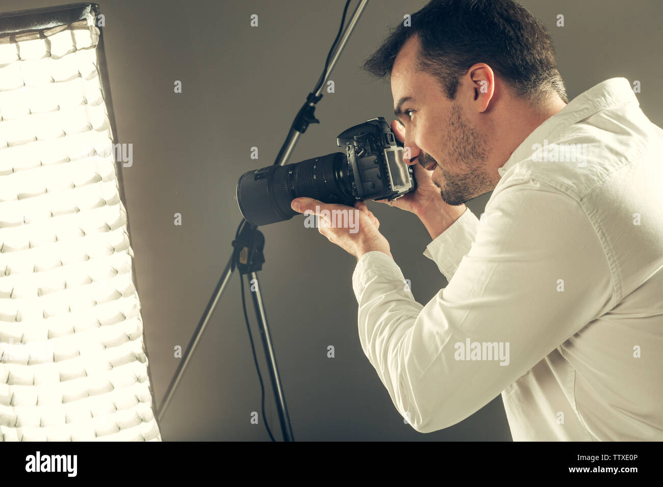 Handsome young man holding a DSLR camera Stock Photo - Alamy