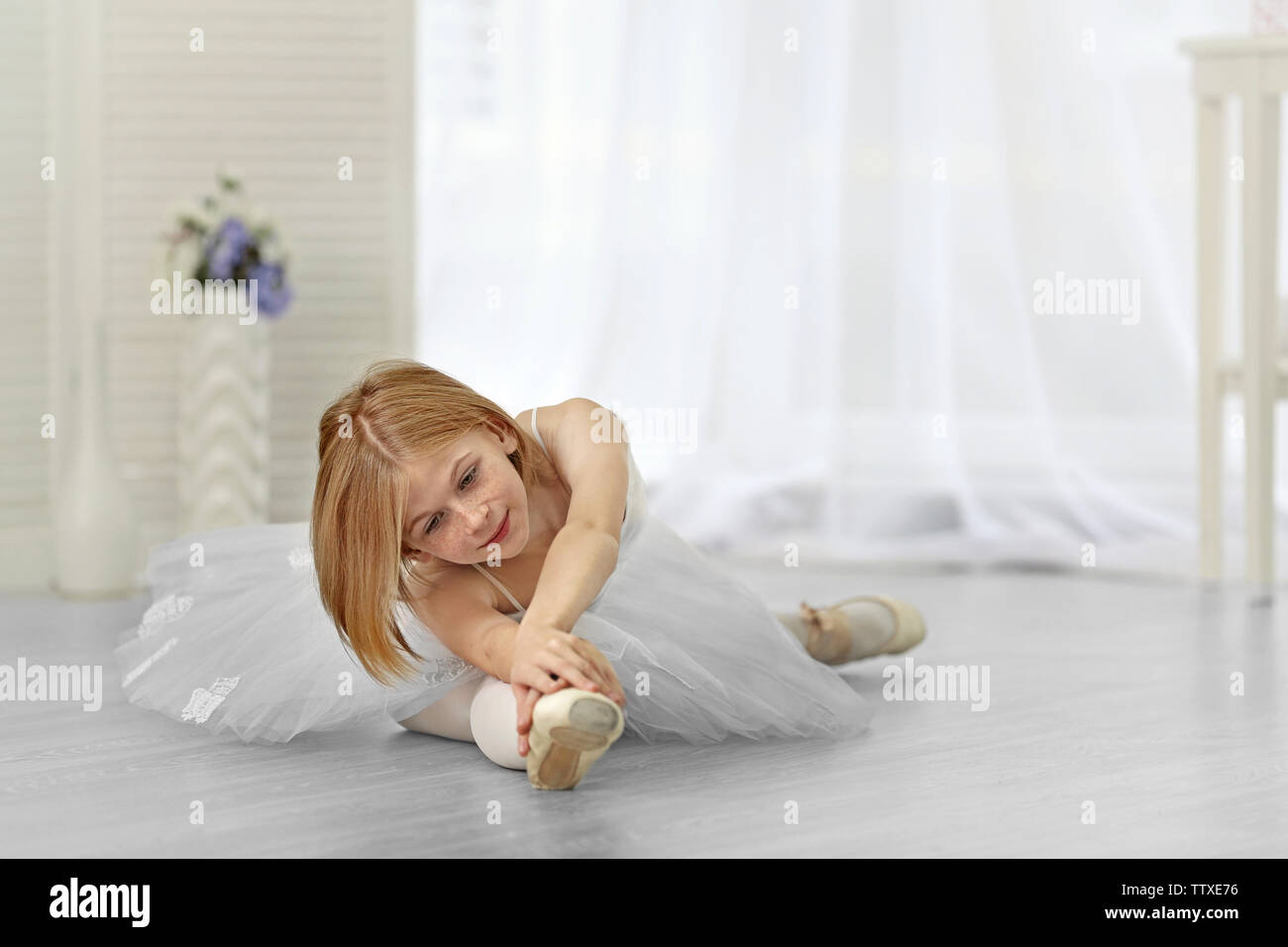 Small ballerina dancer stretching on floor Stock Photo - Alamy