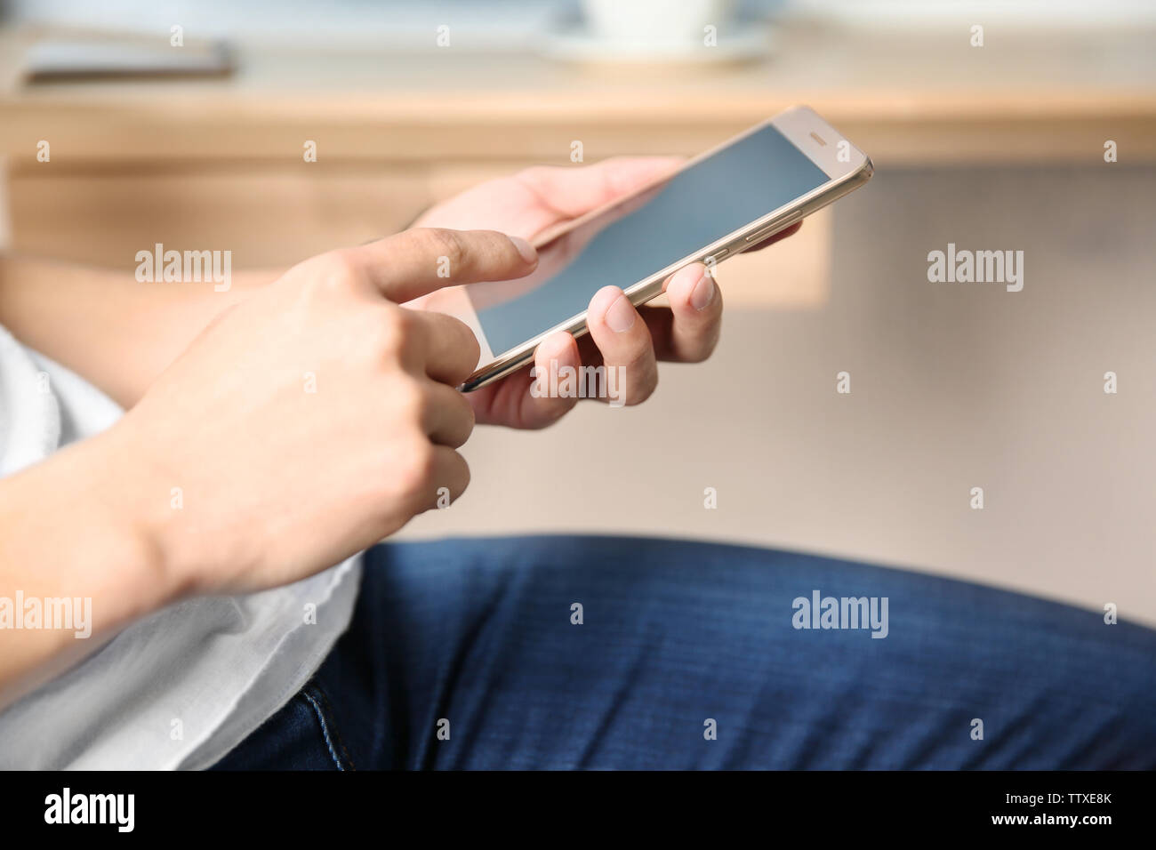 Man using smart phone on room interior background Stock Photo - Alamy