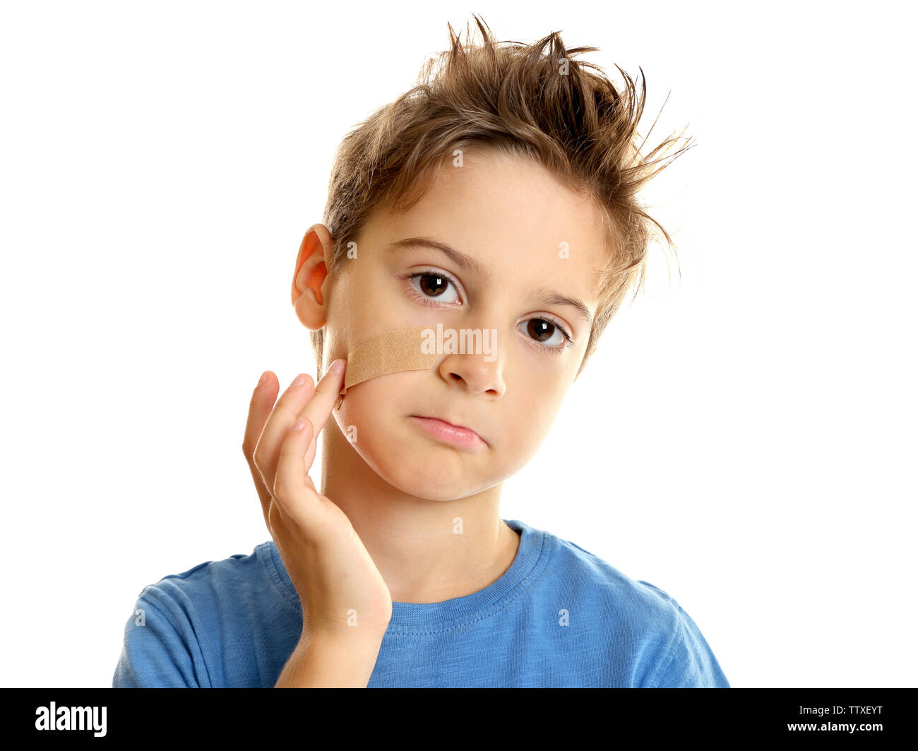Cute little boy with sticking plaster on cheek, on white background ...