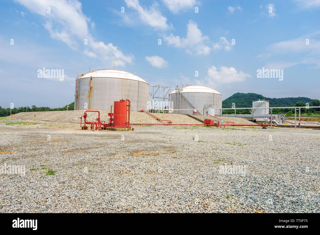 oil tanks stand in empty ground in blue sky Stock Photo - Alamy