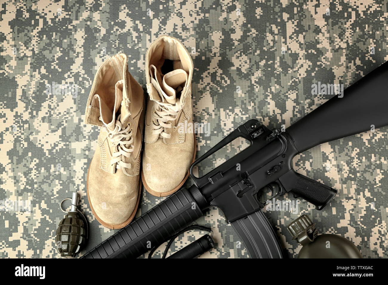 Set of military equipment and combat boots on camouflage background ...