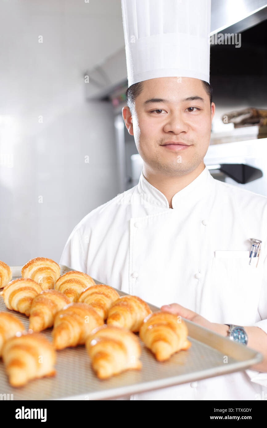 young chinese man chelf making bread in kitchen Stock Photo - Alamy