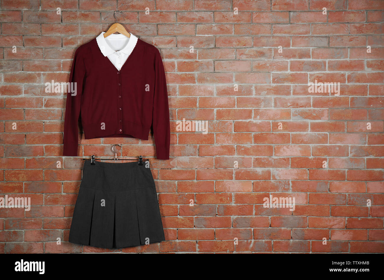 School uniform on brick wall background Stock Photo - Alamy