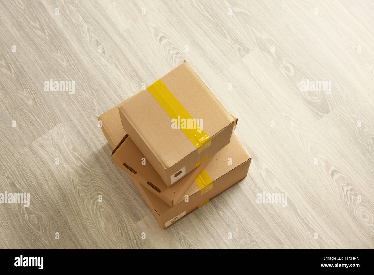 Carton boxes on wooden floor Stock Photo - Alamy