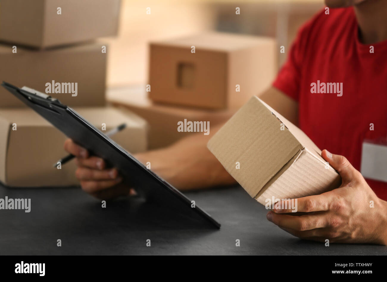 Courier holding carton box and delivery receipt Stock Photo - Alamy